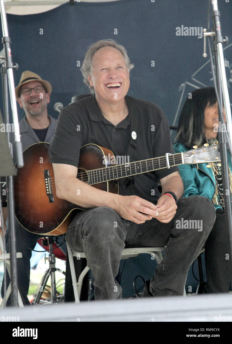 Musician Tom Chapin is shown performing on stage during a "live ...