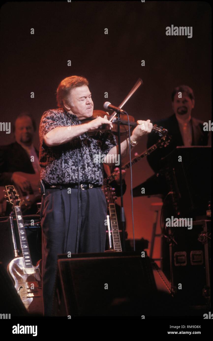 Musician Roy Clark is shown performing on stage during a "live" concert ...