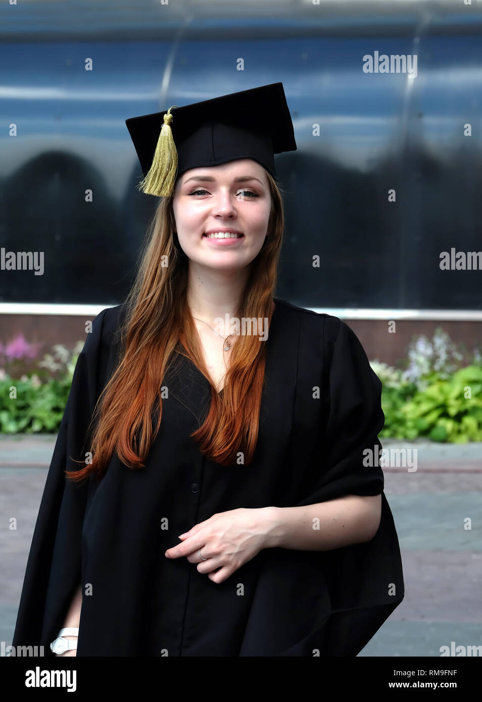Portrait of happy graduate young girl with red hair dressed in black ...