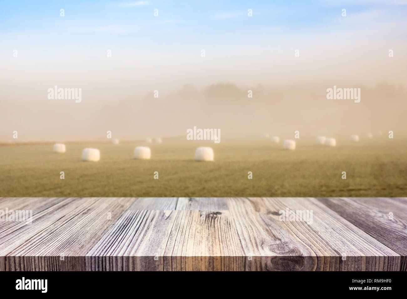 Empty table top for product display montage. Hay bales on farmers field ...