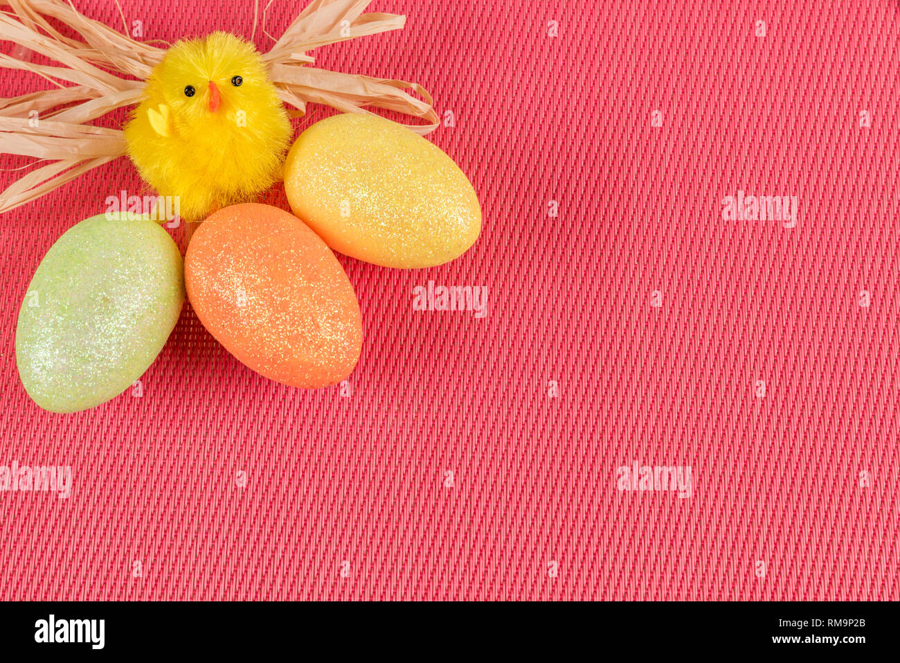 A cheerful easter chicken with three colored eggs on a pink background ...