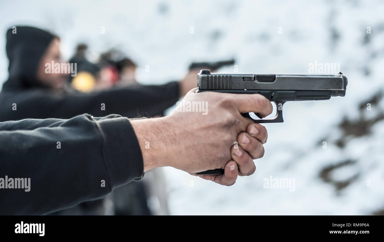 Close-up detail view of shooter practice handgun shooting on target in ...