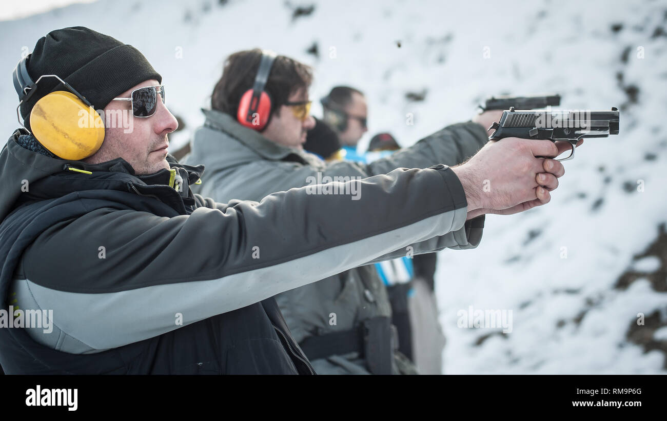 Group of civilian practice gun shoot on target on outdoor shooting ...