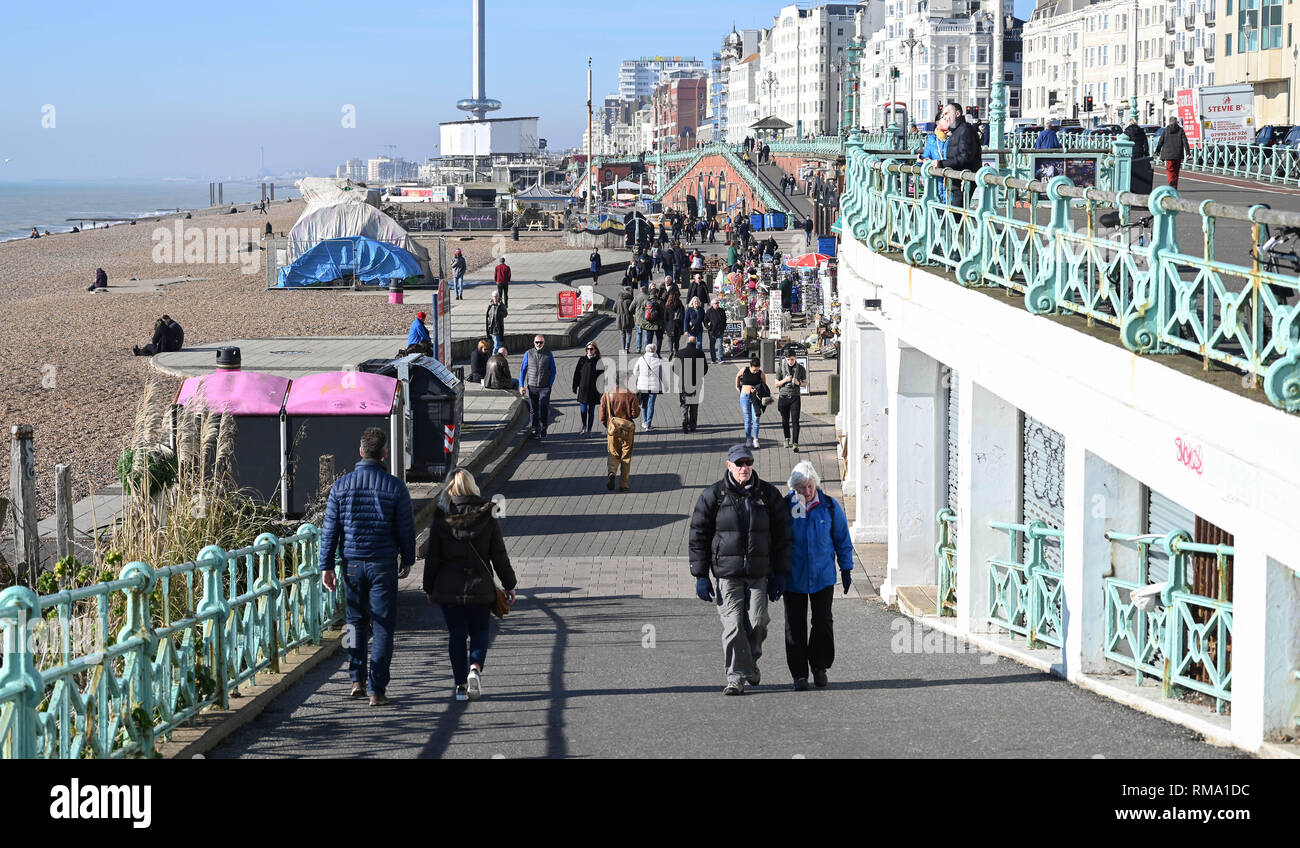 Brighton UK 14th February 2019 - Visitors enjoy a walk a sunny walk ...