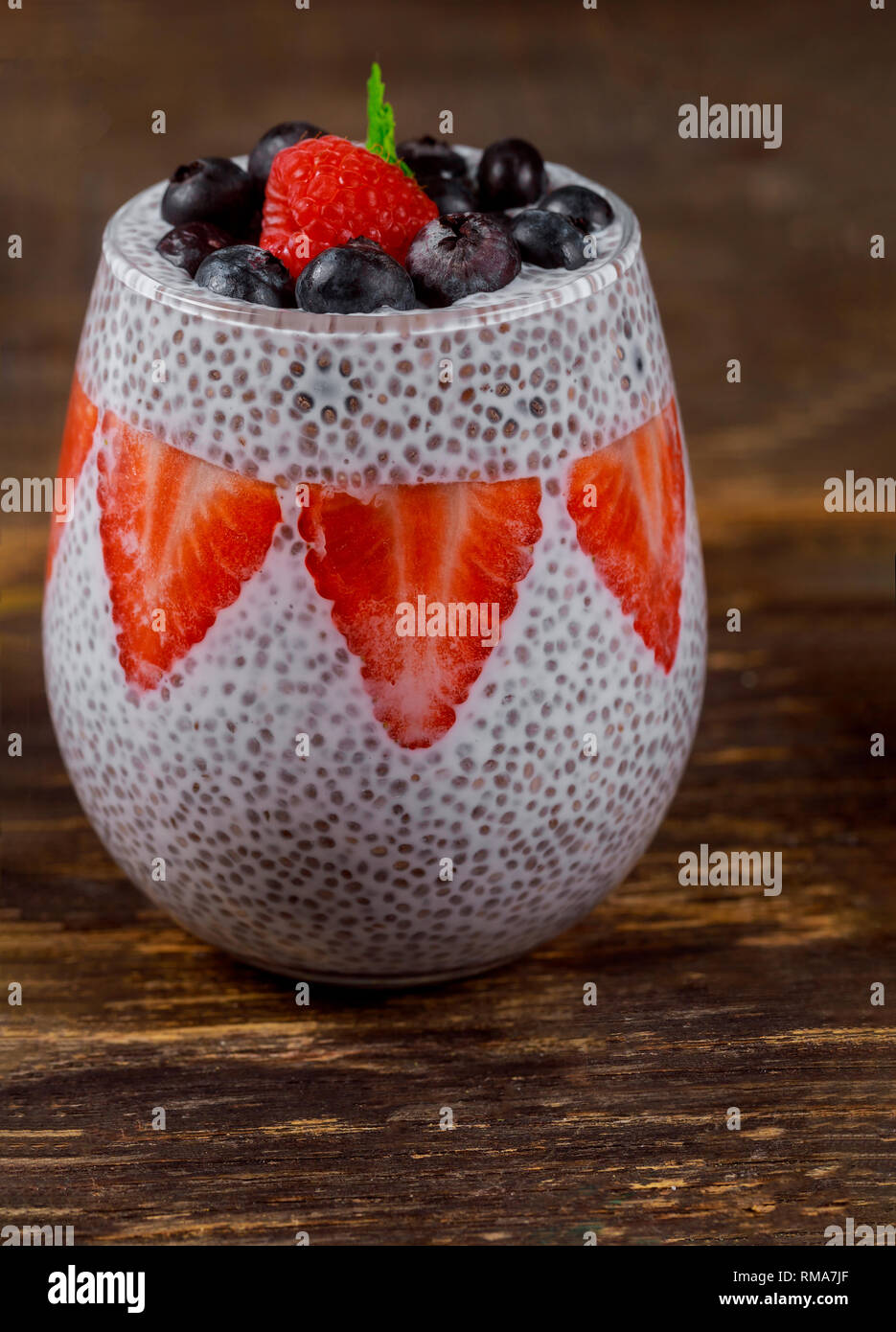 Chia Pudding with decorated with ripe strawberry in transparent glasses ...