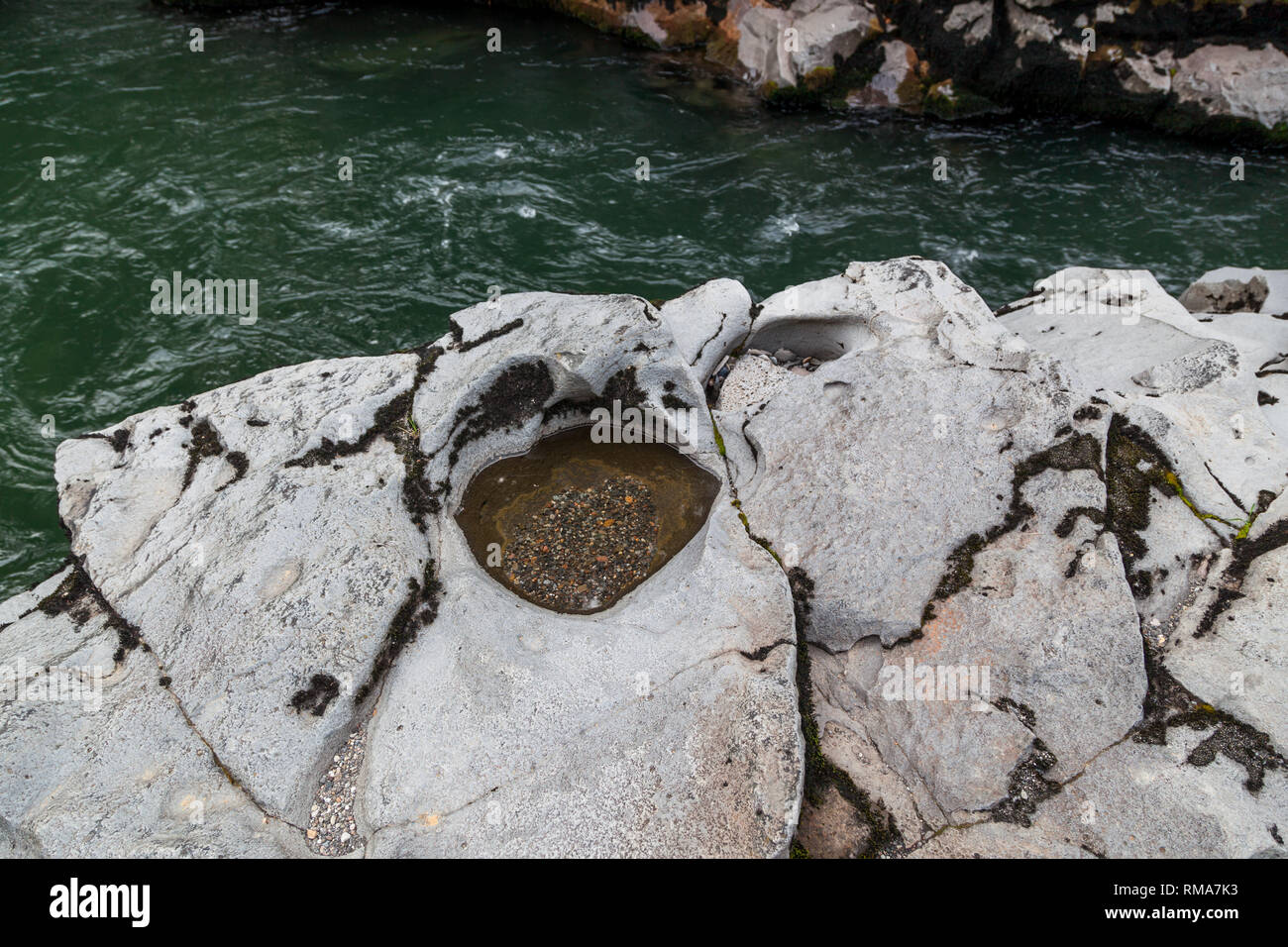Volcanic rock on the shore of the Upper Rogue River that has been ...