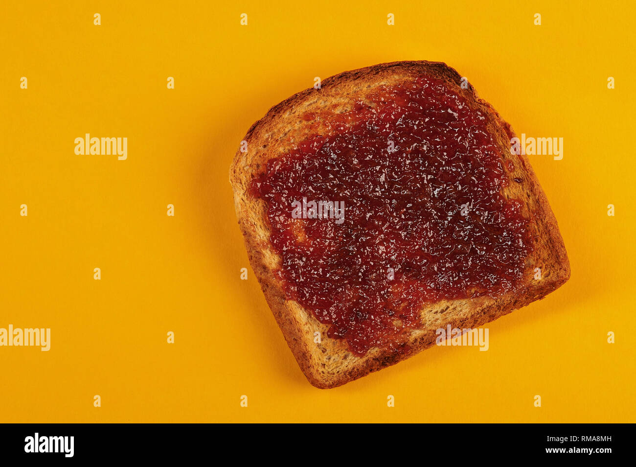 Toast with jelly on top isolated yellow background Stock Photo - Alamy