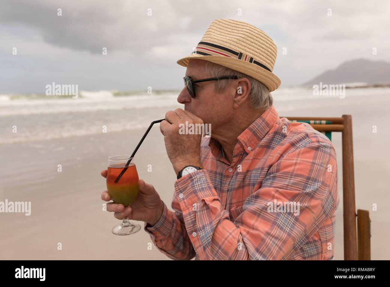 Senior man having cocktail drink while relaxing in a sun lounger Stock ...