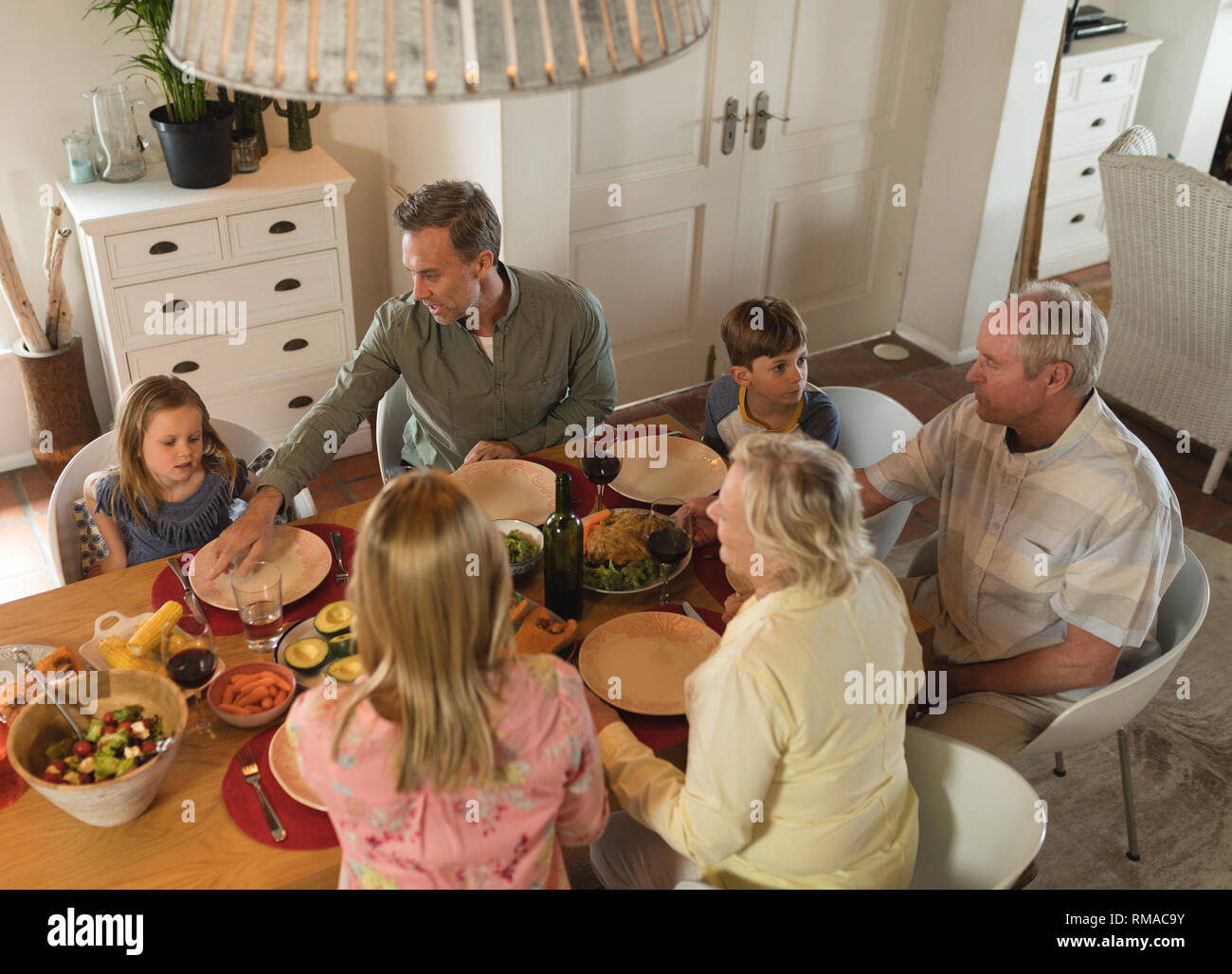 Family interacting with each other while having meal Stock Photo - Alamy