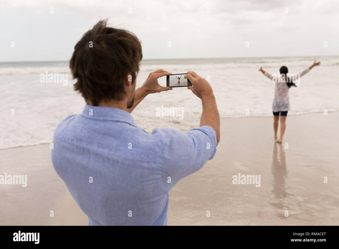 Man clicking photo of woman with mobile phone Stock Photo - Alamy