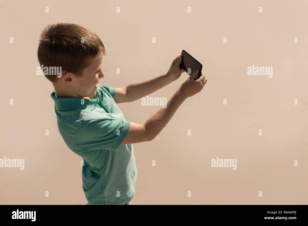 Boy looking at mobile phone standing hi-res stock photography and ...