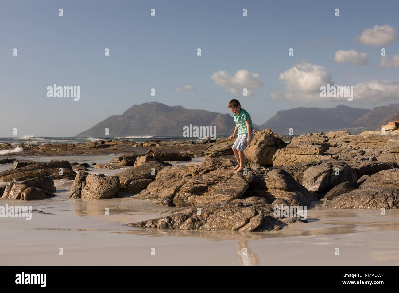 Boy walking on rocks at beach Stock Photo - Alamy