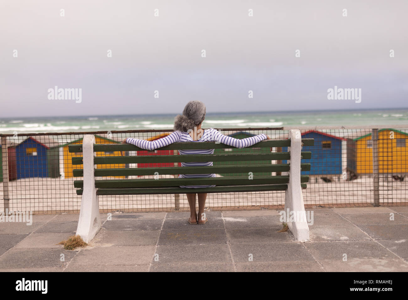 Senior woman sitting on promenade bench at beach Stock Photo - Alamy