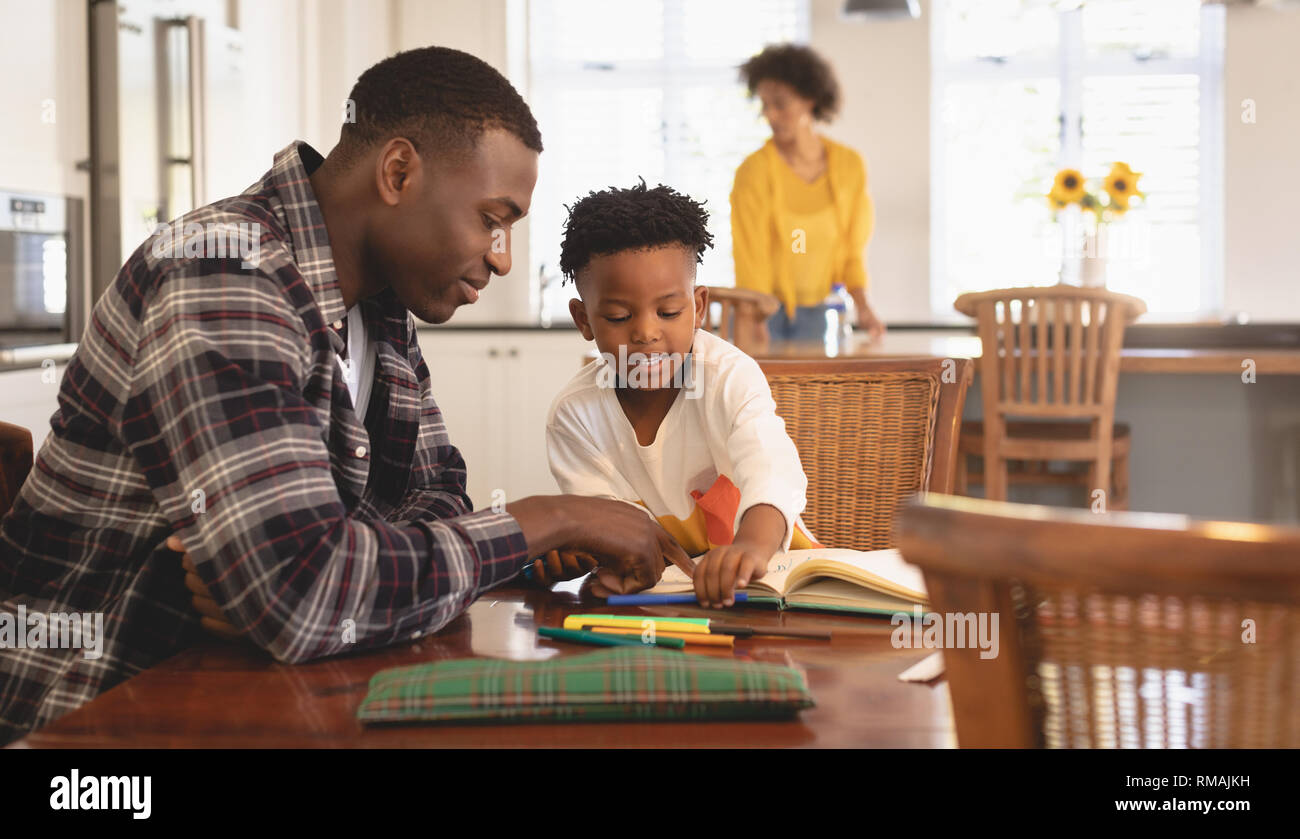African American father helping his son with homework at table Stock ...