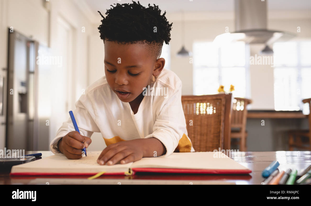 Cute African American boy doing homework at table Stock Photo - Alamy