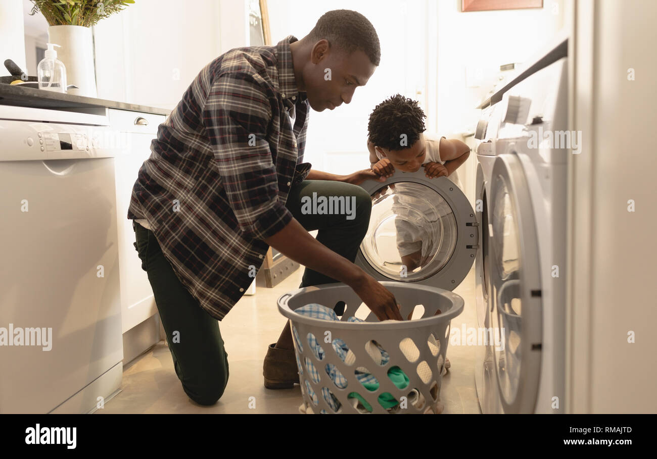 Father and son washing clothes in washing machine Stock Photo - Alamy