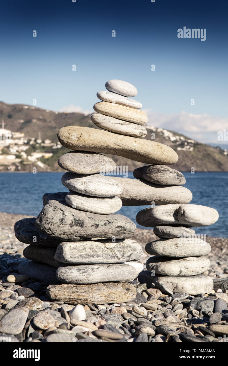 Rock balancing or stone balancin, naturally balanced on a beach with ...