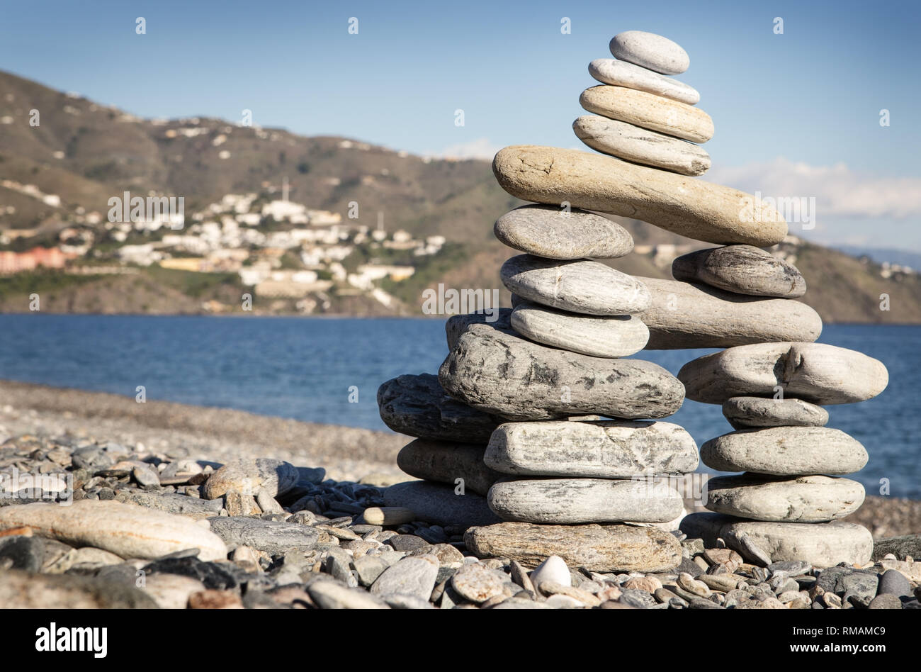 Rock balancing or stone balancin, naturally balanced on a beach with ...