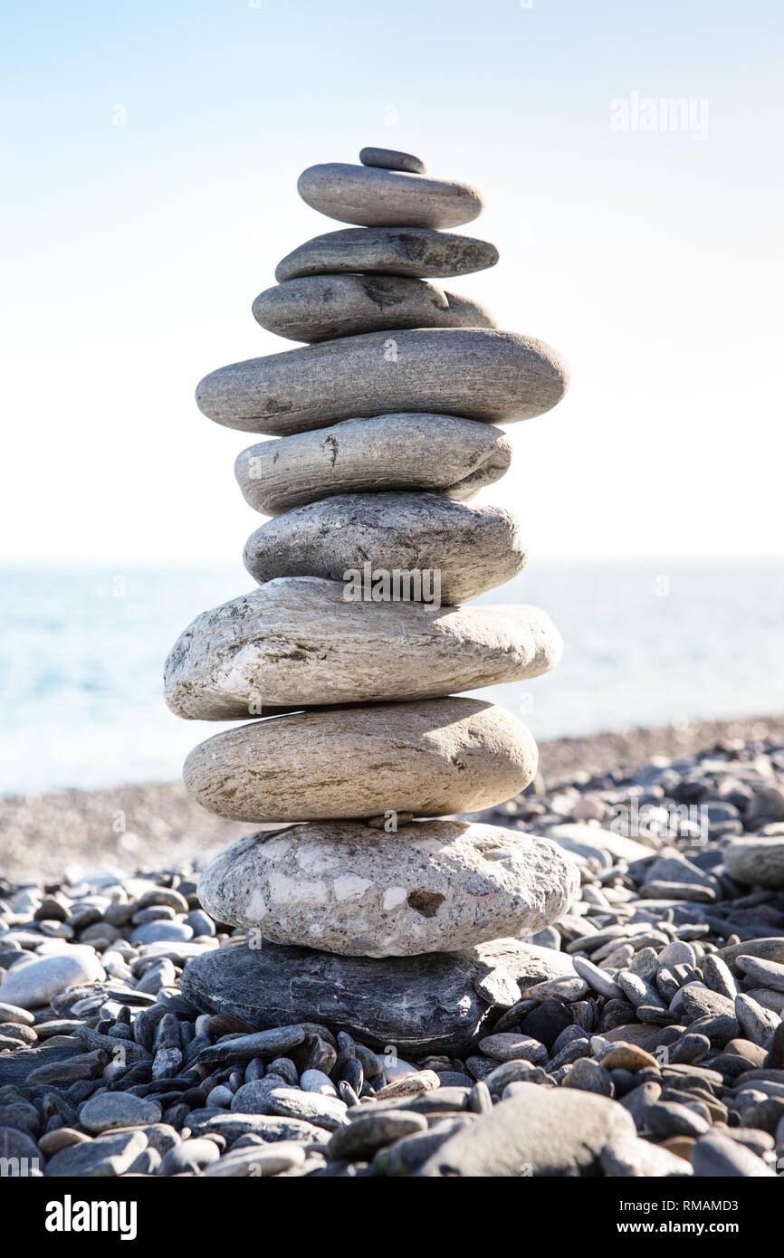 Rock balancing or stone balancin, naturally balanced on a beach with ...