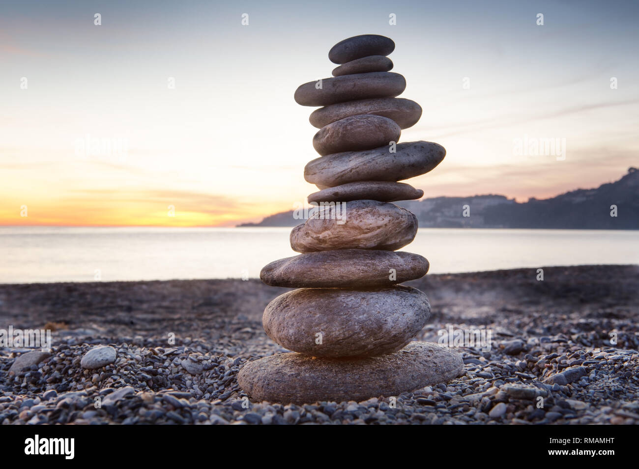 Rock balancing or stone balancin, naturally balanced on a beach with ...