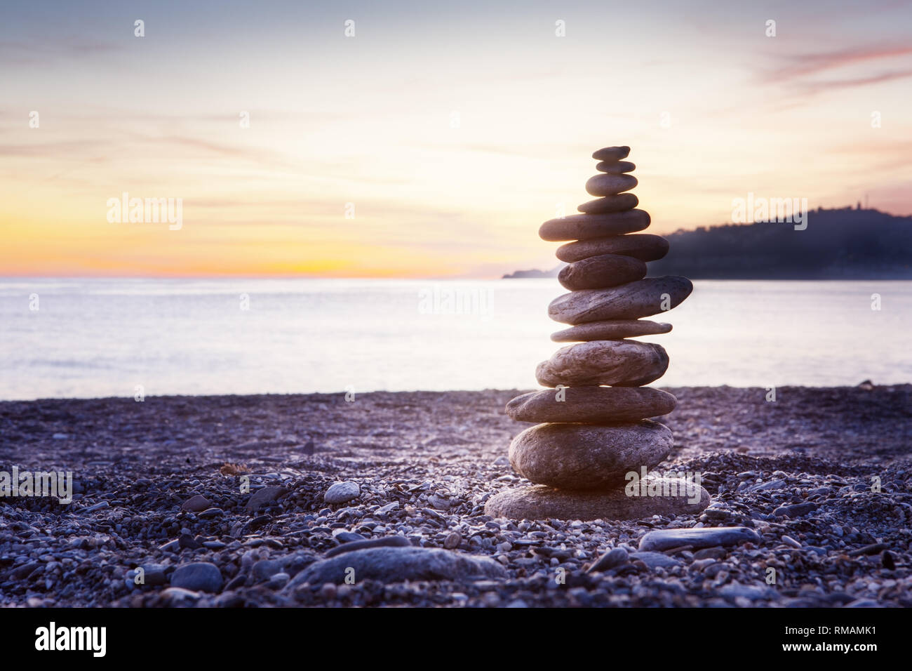 Rock balancing or stone balancin, naturally balanced on a beach with ...
