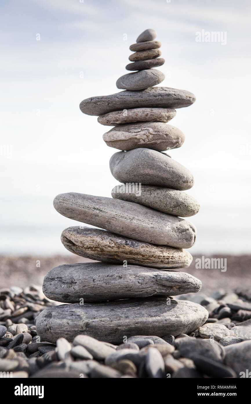 Rock balancing or stone balancin, naturally balanced on a beach with ...