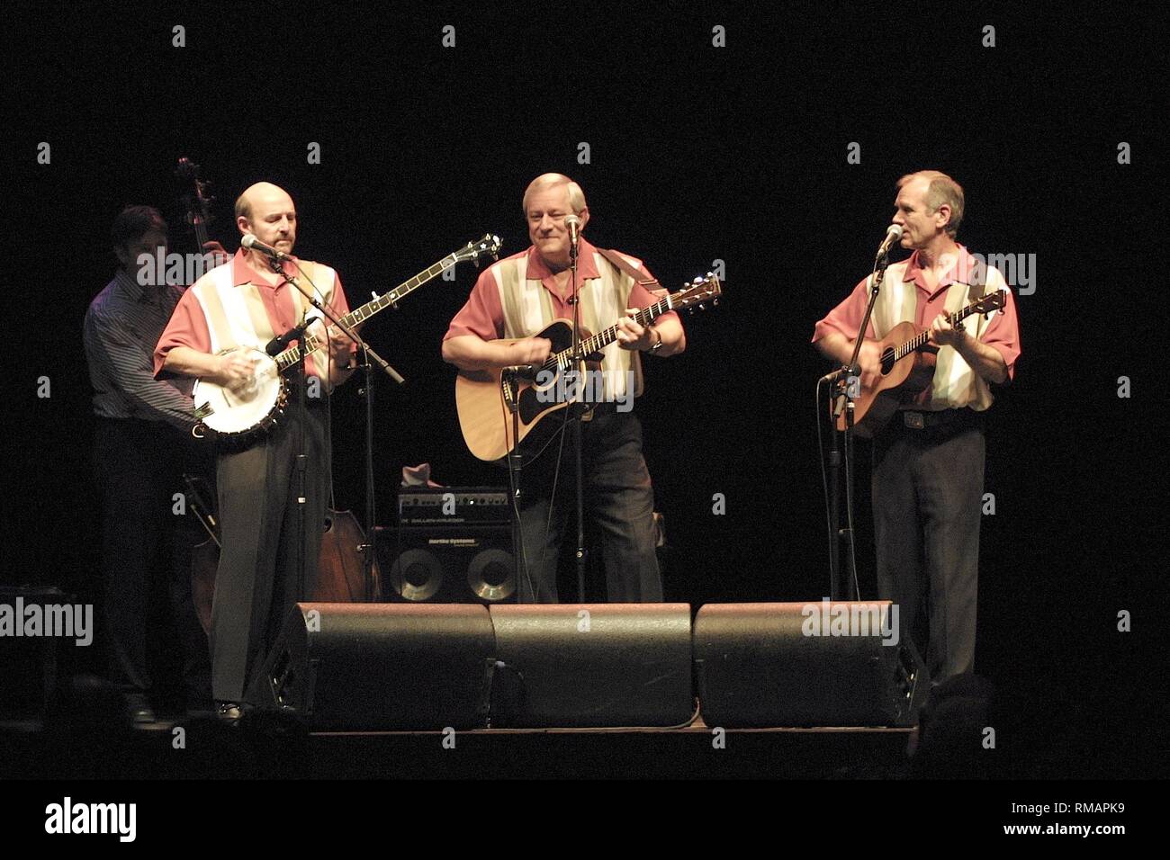 A musician of the Kingston Trio is shown performing on stage during a ...