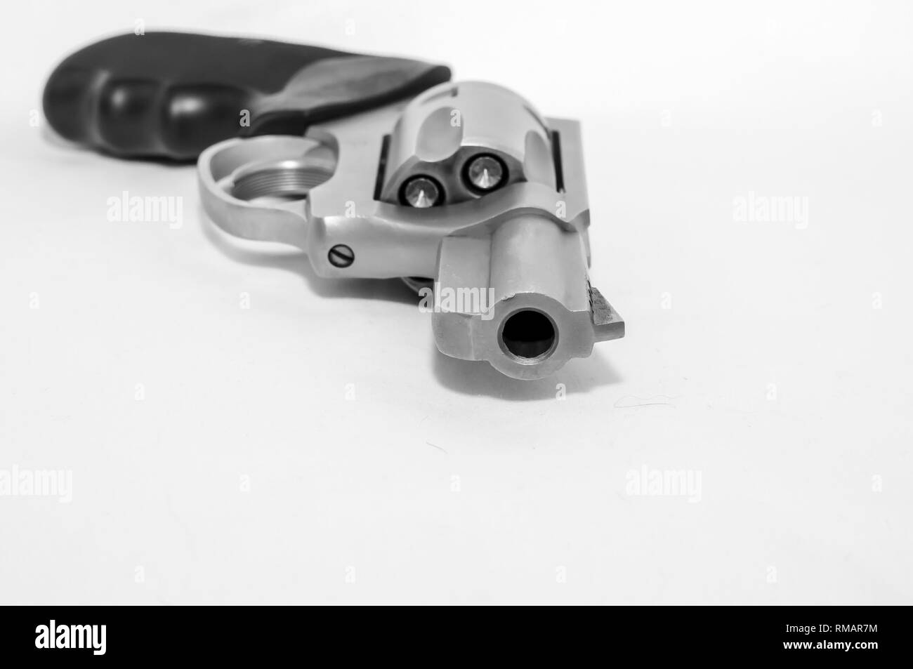 A loaded 357 magnum revolver on its side on a white background shown in ...