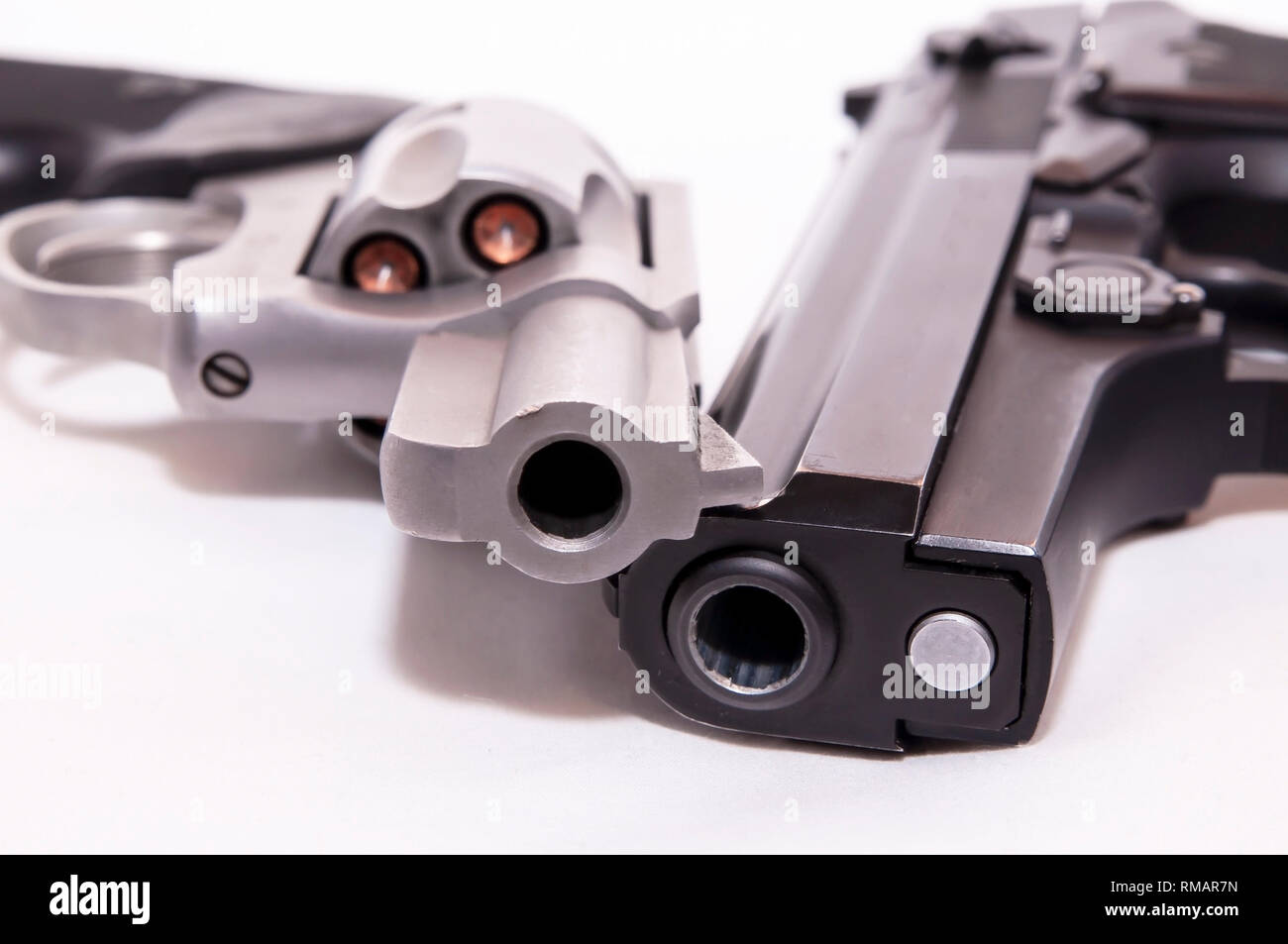 Two handguns, a 40 caliber pistol and a 357 magnum revolver on a white ...