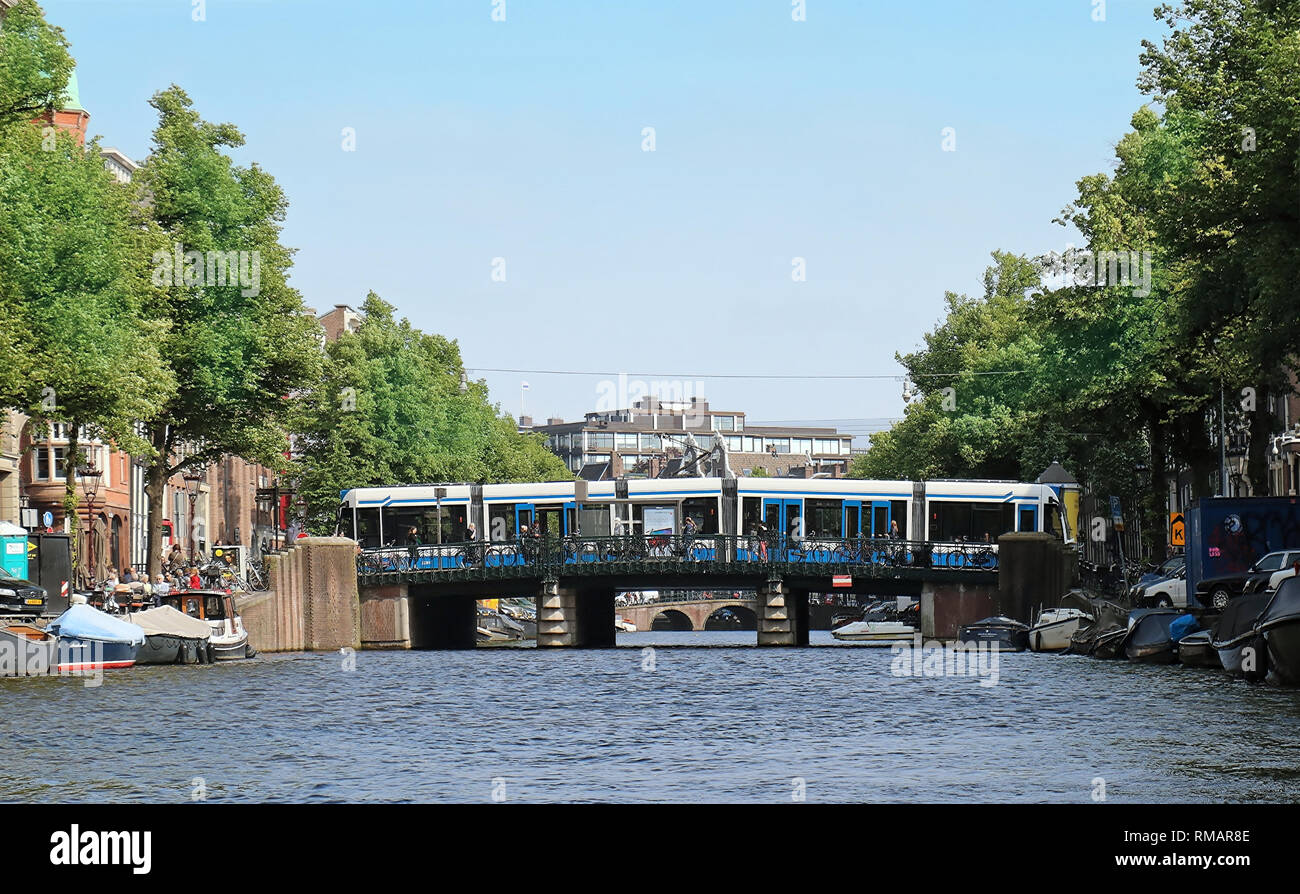 Public transport tram on station stop on bridge over Amsterdam canal ...