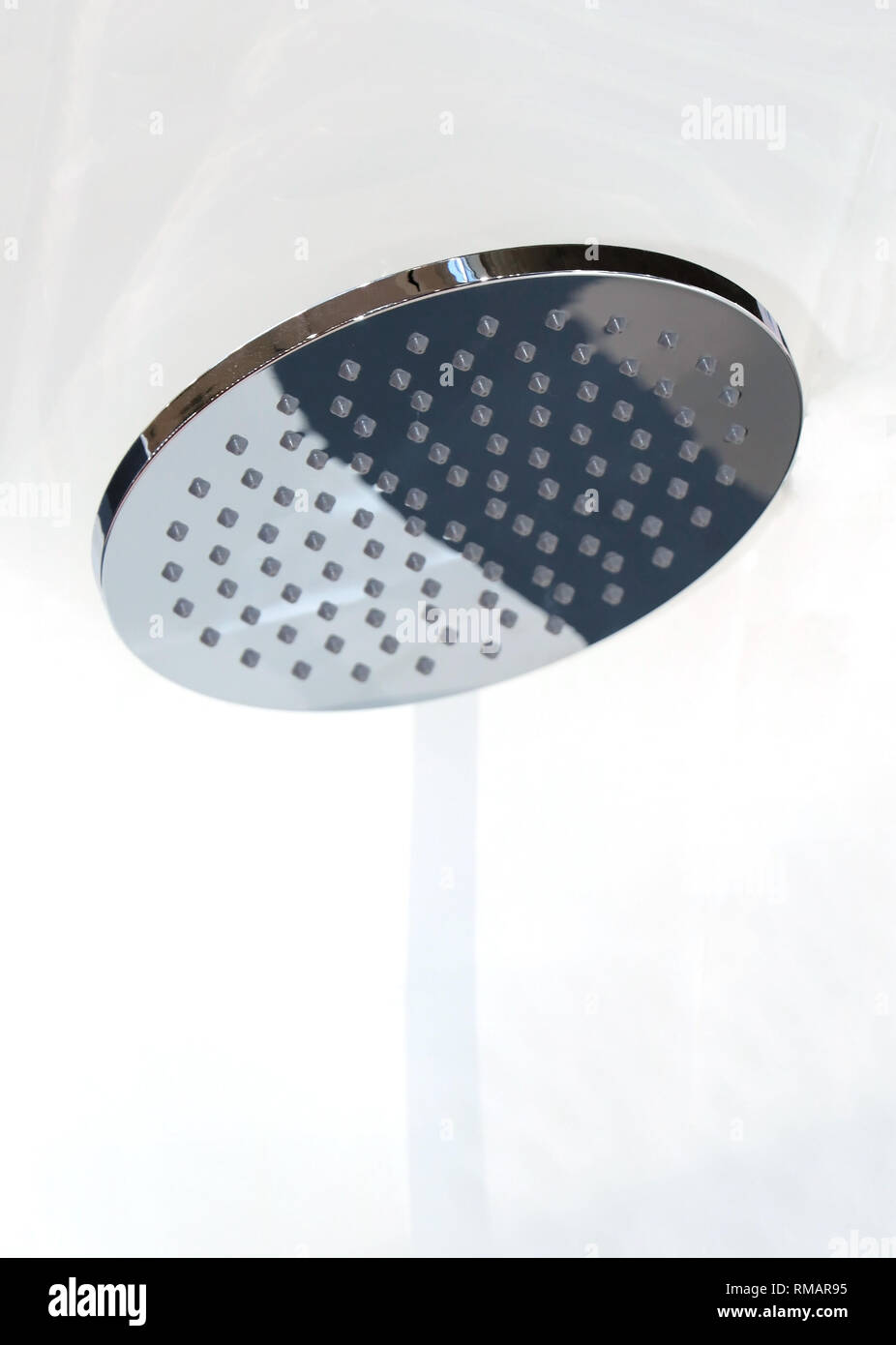 Large silver shower head on white background inside modern bathroom ...