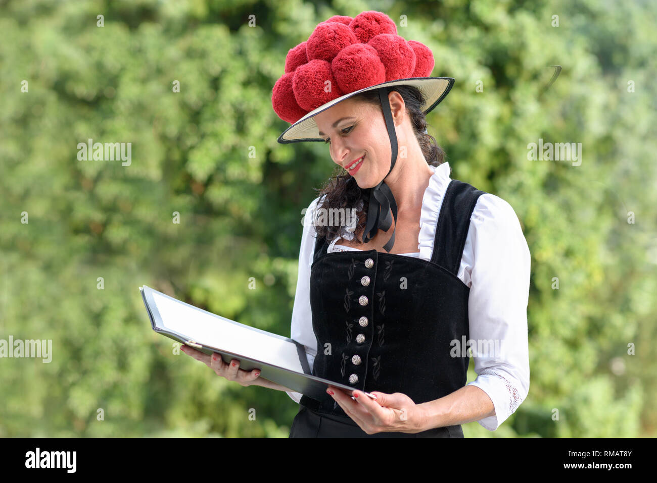 A portrait of a beautiful german waitress wearing a bollenhut and ...