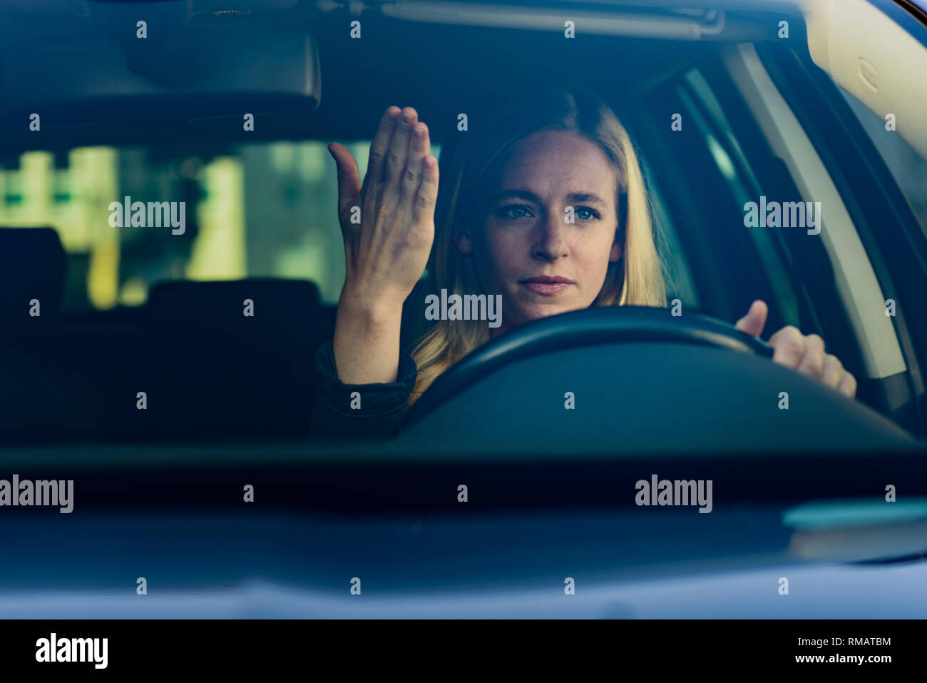 Front view of young frustrated blond woman driving car Stock Photo - Alamy