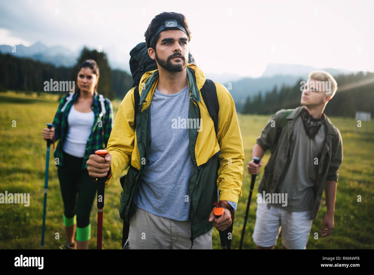 Group of young friends hiking in countryside. Multiracial young people ...