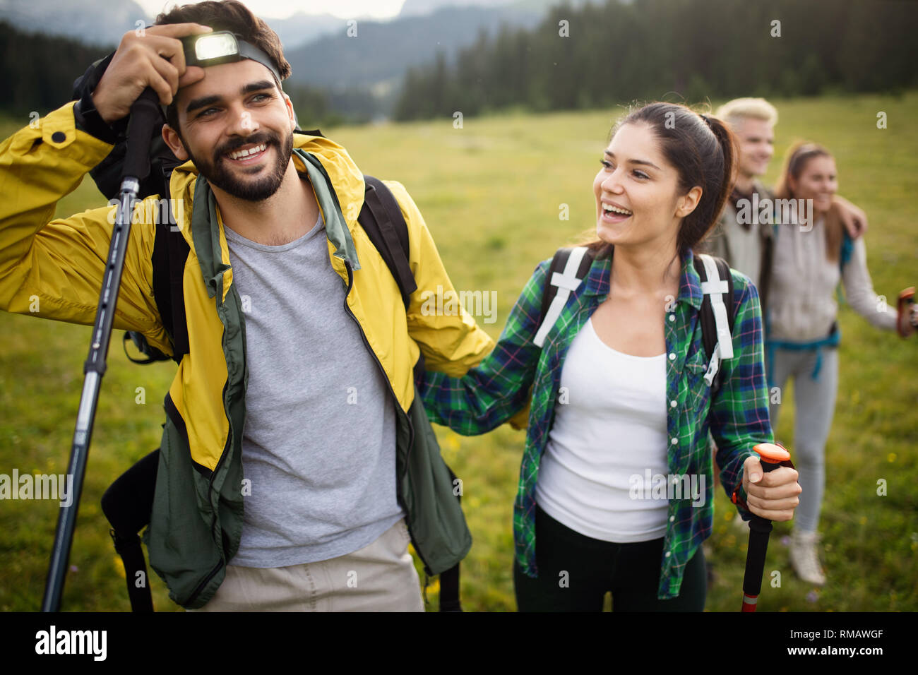 Group of hikers walking on a mountain and smiling Stock Photo - Alamy