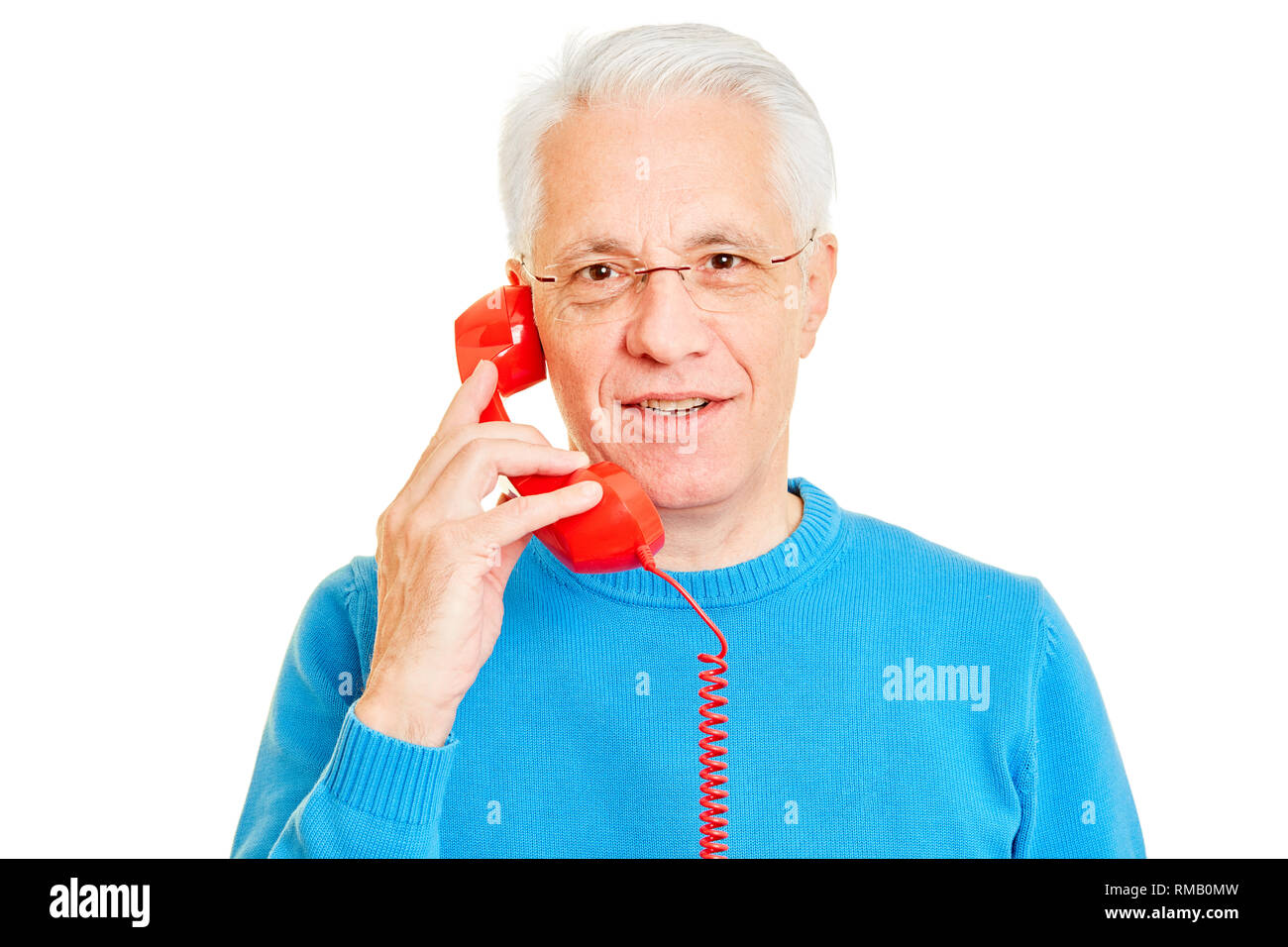 Senior man is on the phone with an old red phone Stock Photo - Alamy