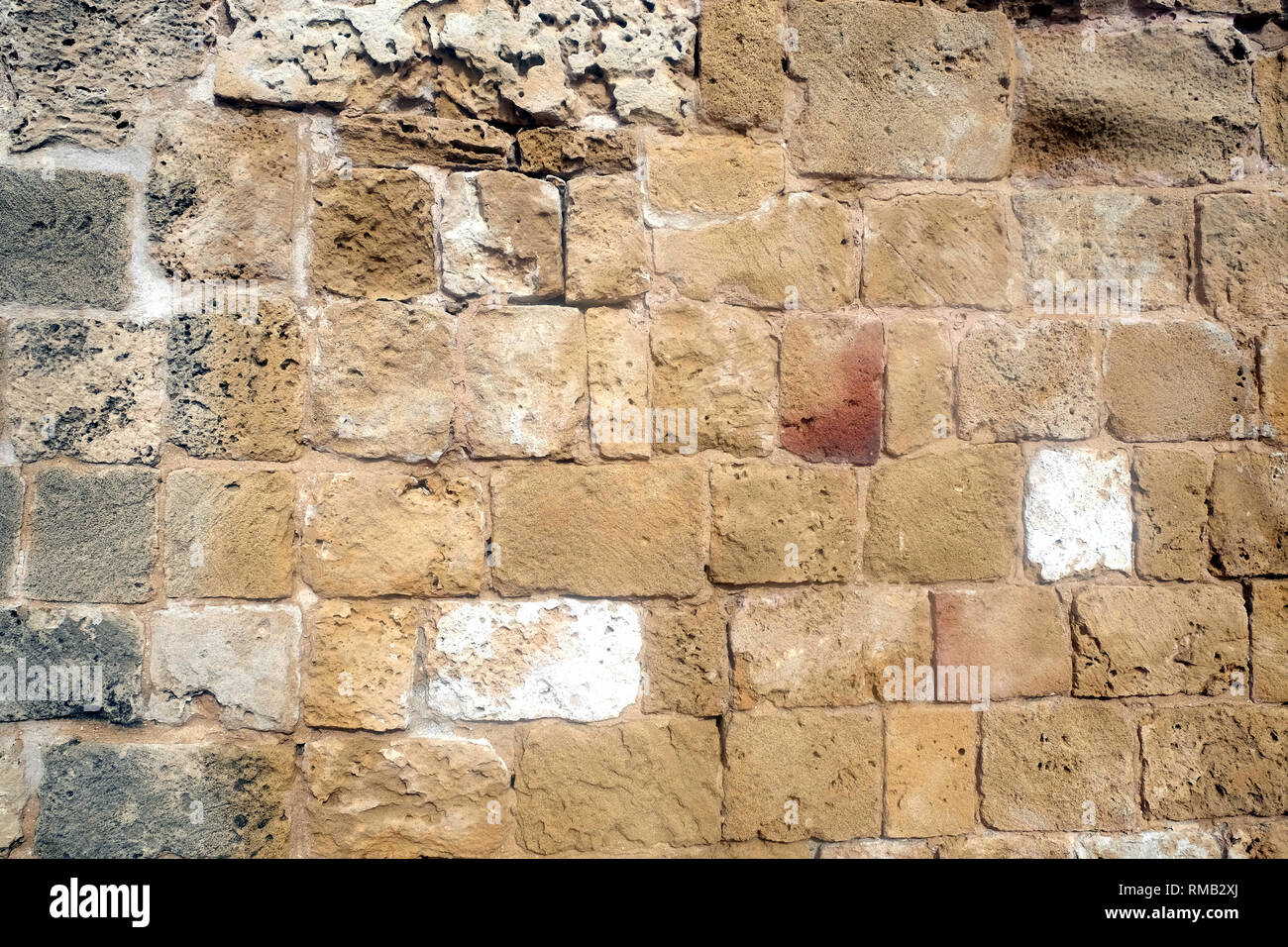 Old antique wall from demaged sandy brown stones front view closeup ...