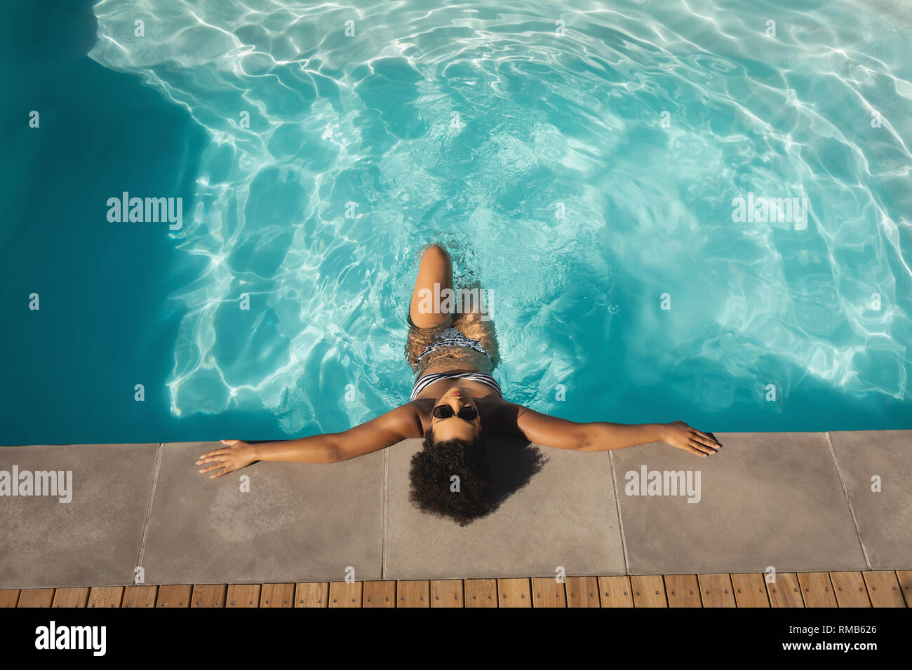Woman leaning on edge of swimming pool hi-res stock photography and ...