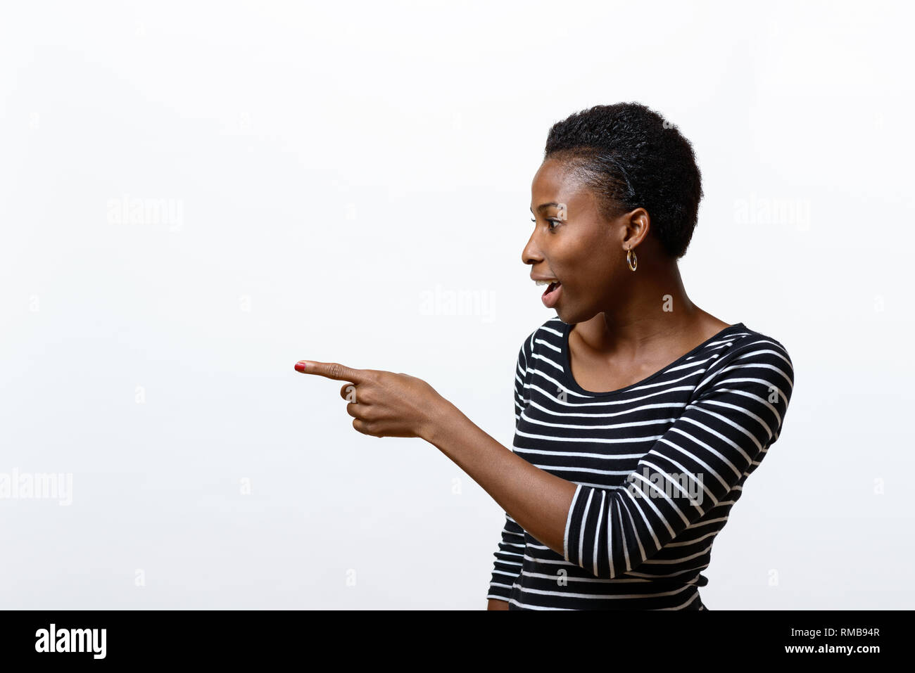 Smiling African woman pointing to the side towards blank copy space on ...