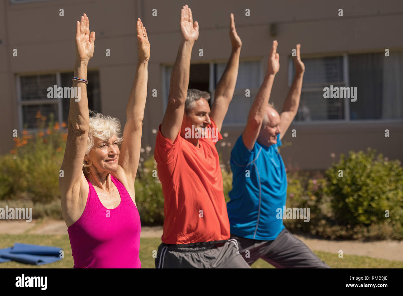 Trainer training senior people in performing exercise Stock Photo - Alamy