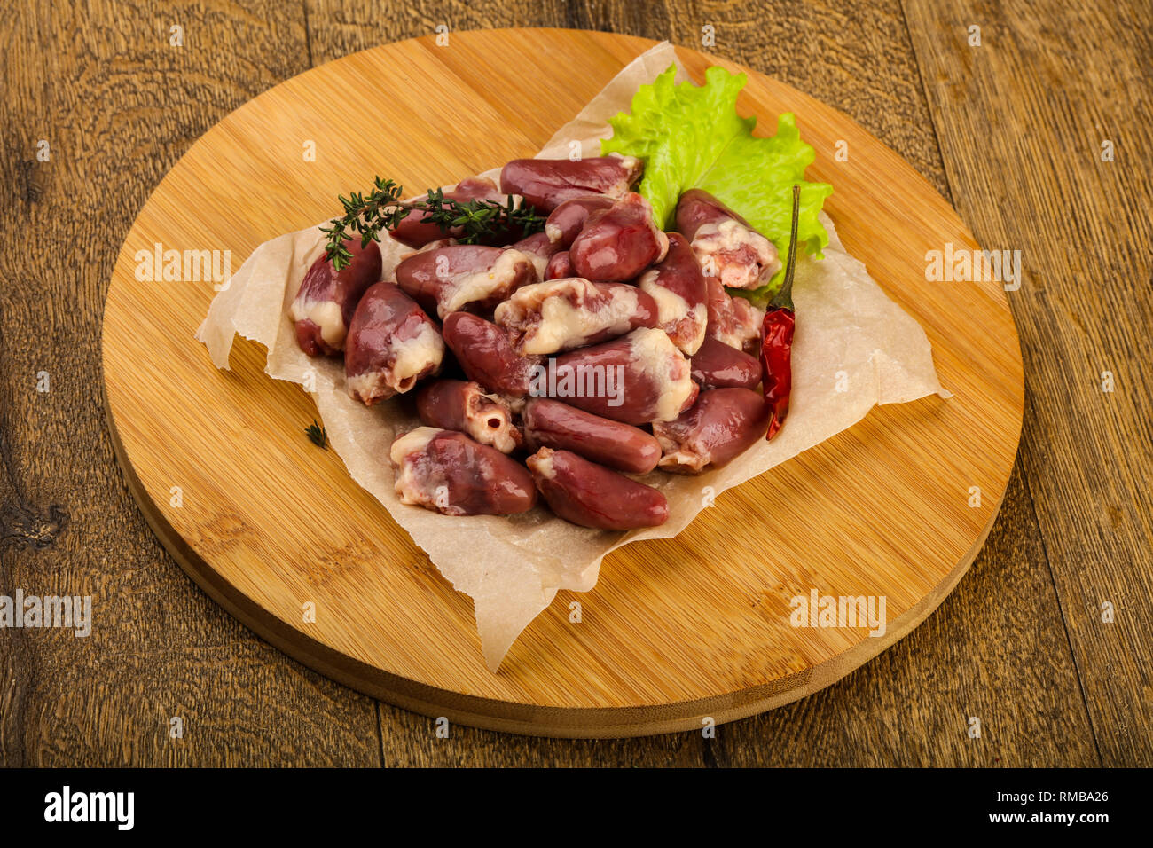 Raw chicken hearts heap with thyme branch Stock Photo - Alamy