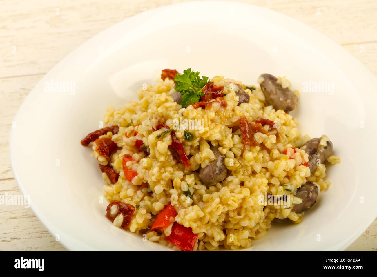 Bulgur with chicken hearts and dry tomatoes Stock Photo - Alamy