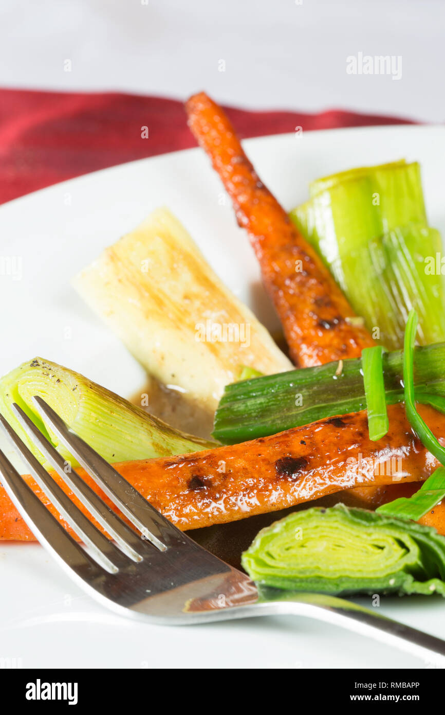 A vegan restaurant main course of Charred carrot and leek served with a ...