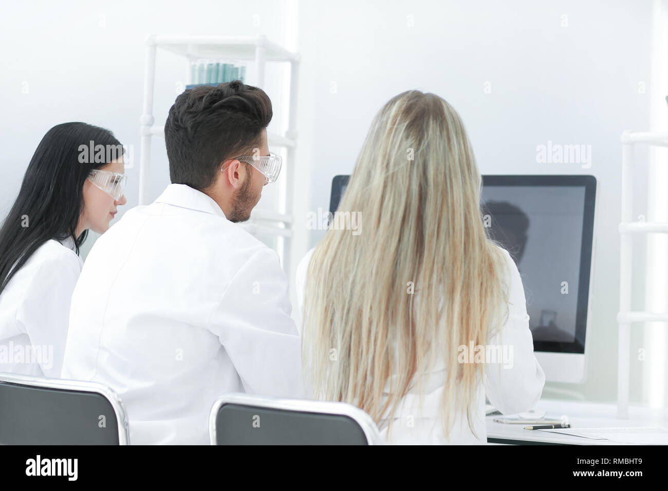 rear view.a group of scientists look at the computer monitor Stock ...
