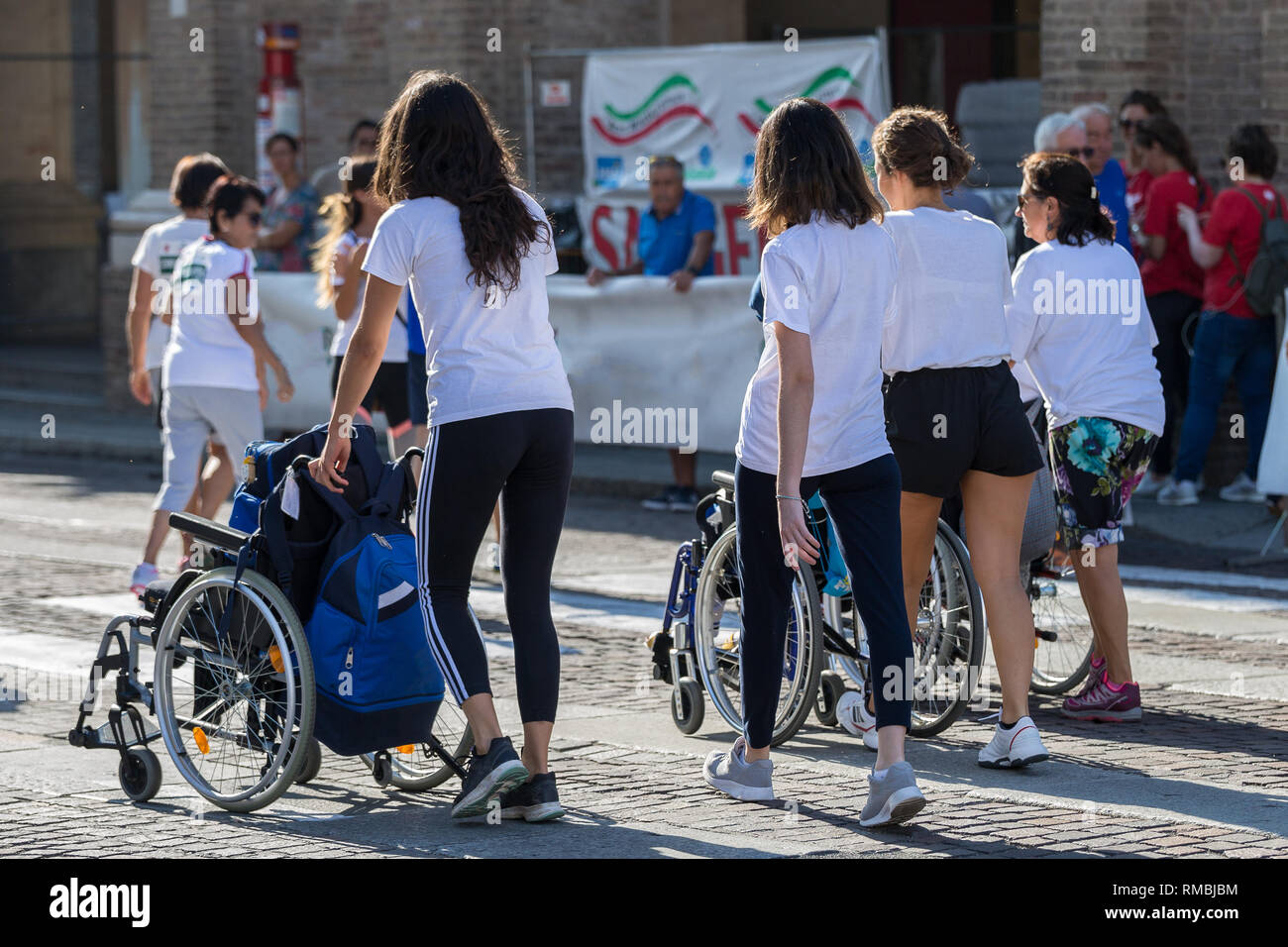 Disabled Athlete in a Sport Wheelchair during Marathon Helped by Female ...