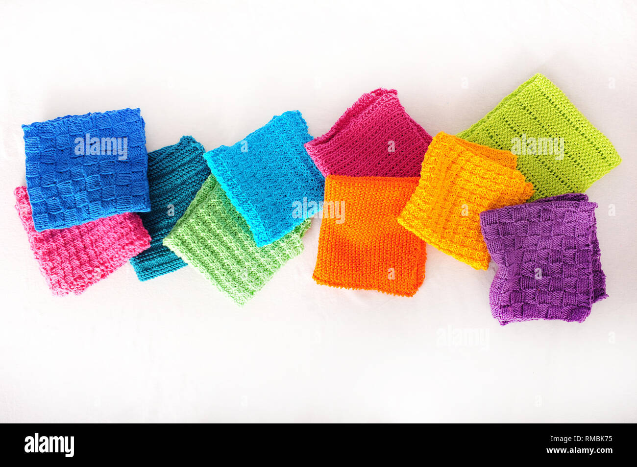 Row of colorful dishcloths on white surface. Horizontal photo with copy ...