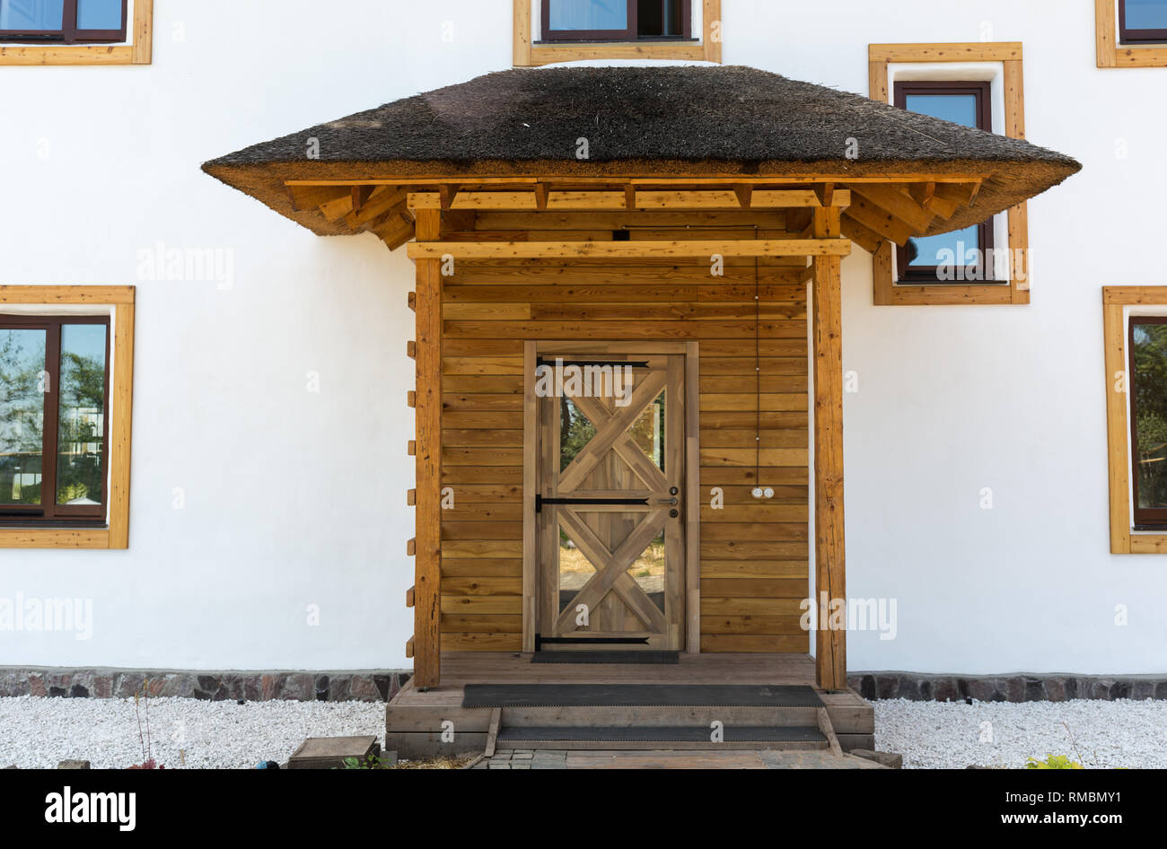 old building with wooden doors and potted plants on street in Castel ...
