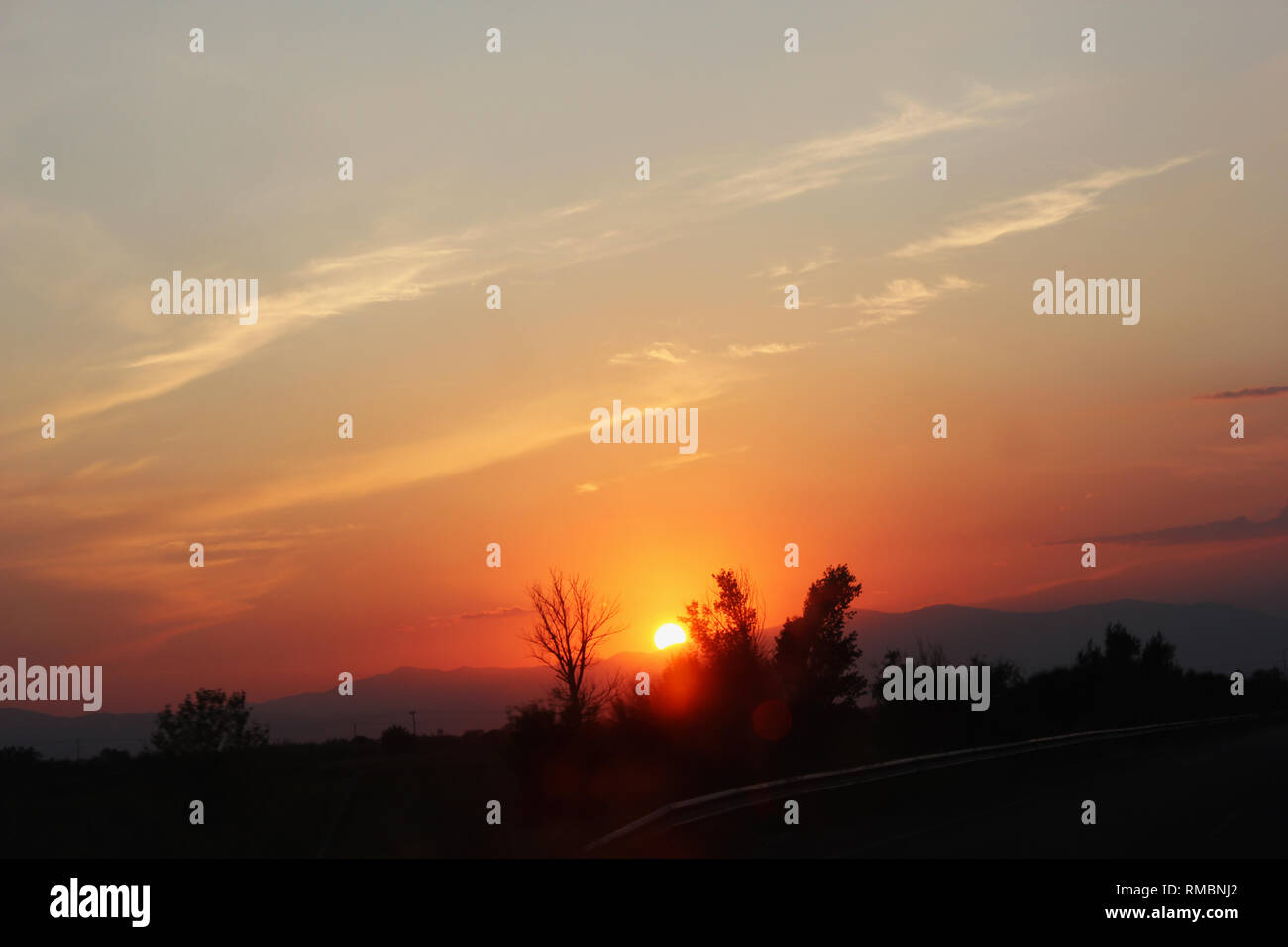 Amazing sunset sunrise with sun over mountain Stock Photo - Alamy