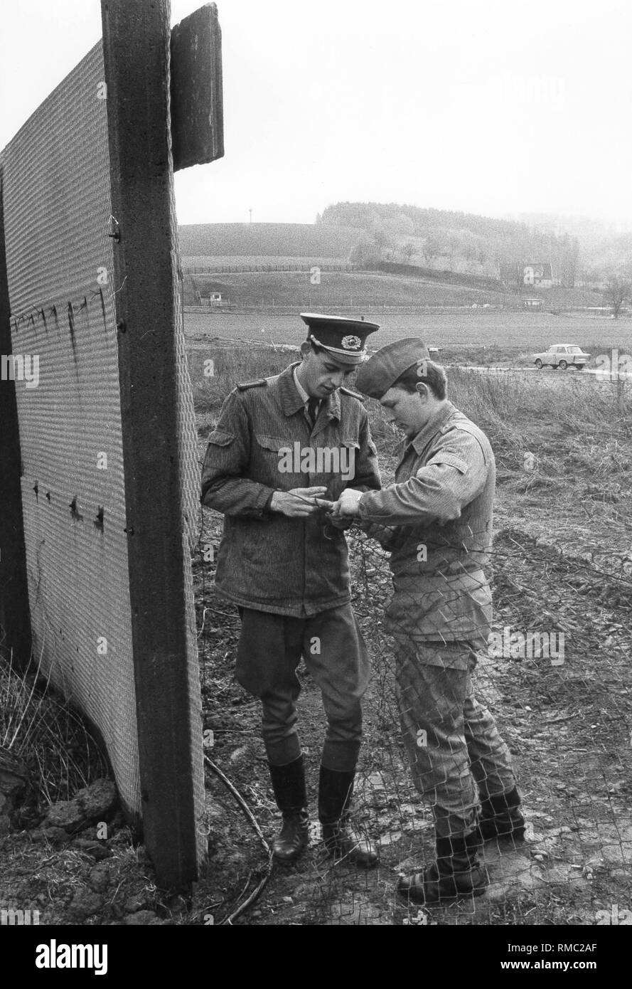 Members of the GDR border troops dismantle the wire fence on the inner ...