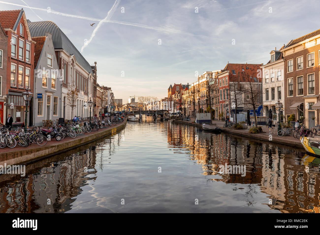 Canal view with old canal houses on either side reflected in the water ...
